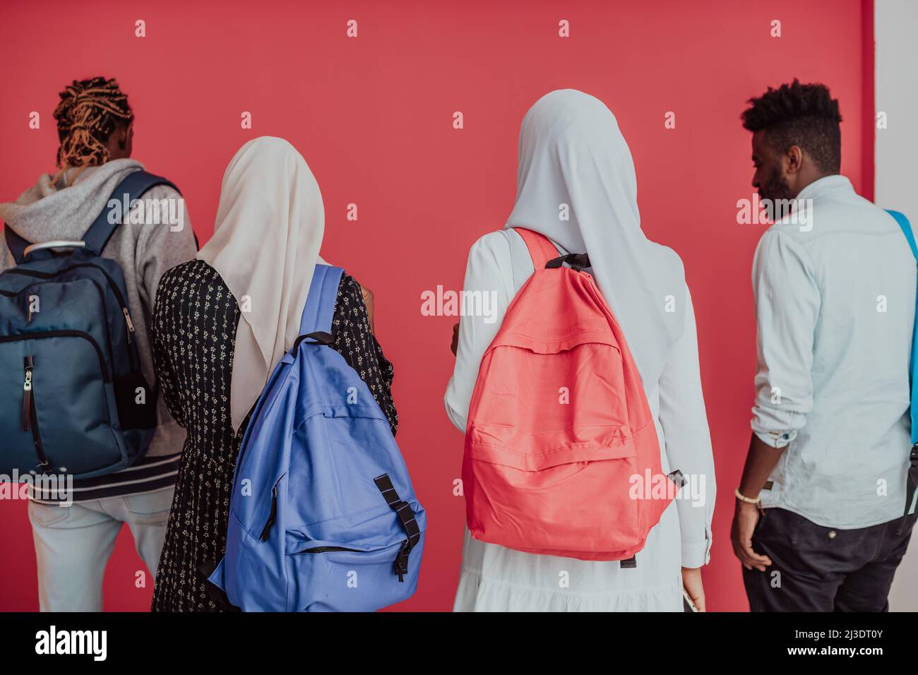 A group of African Muslim students with backpacks posing on a pink ...