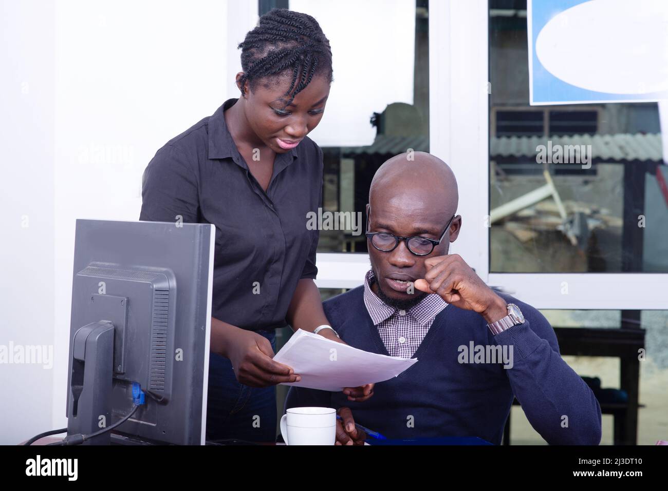 Serious businessman and secretary, checking together notes on the ...