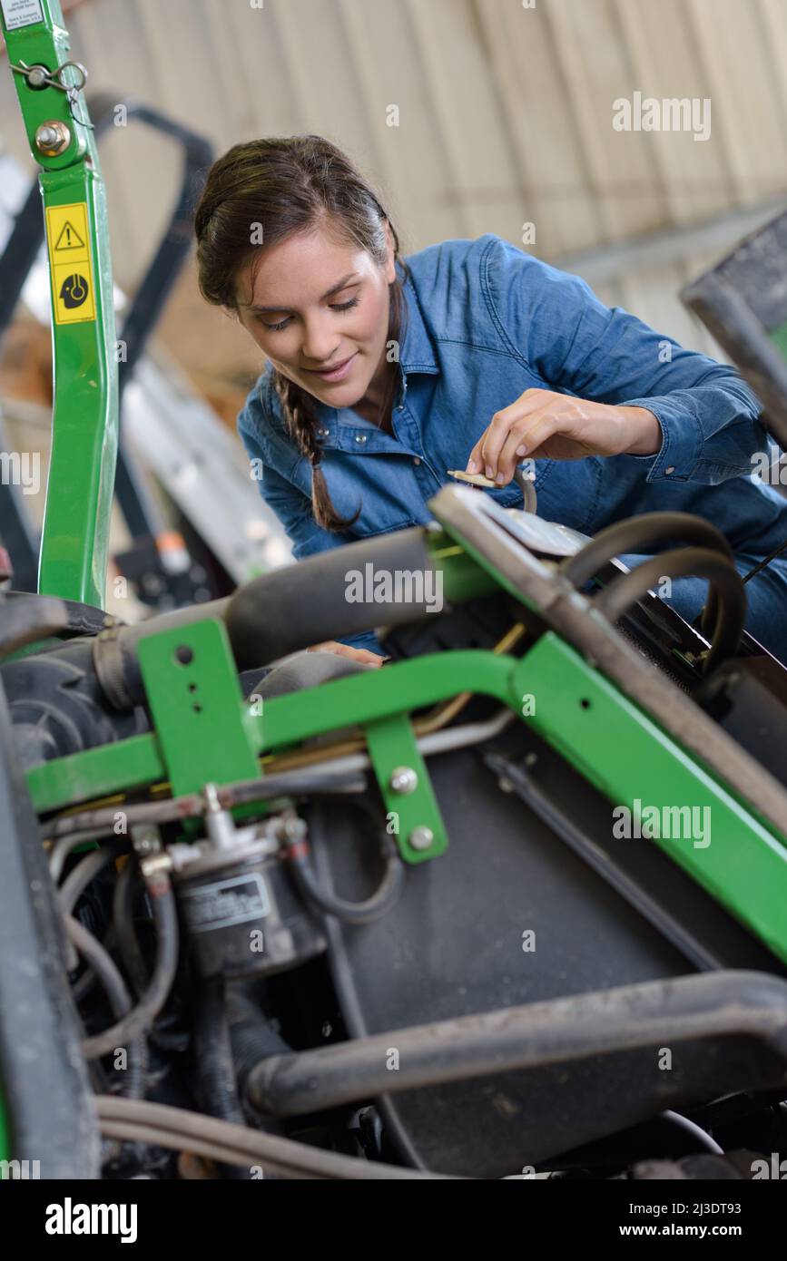 female agricultural mechanic checking tractor Stock Photo - Alamy