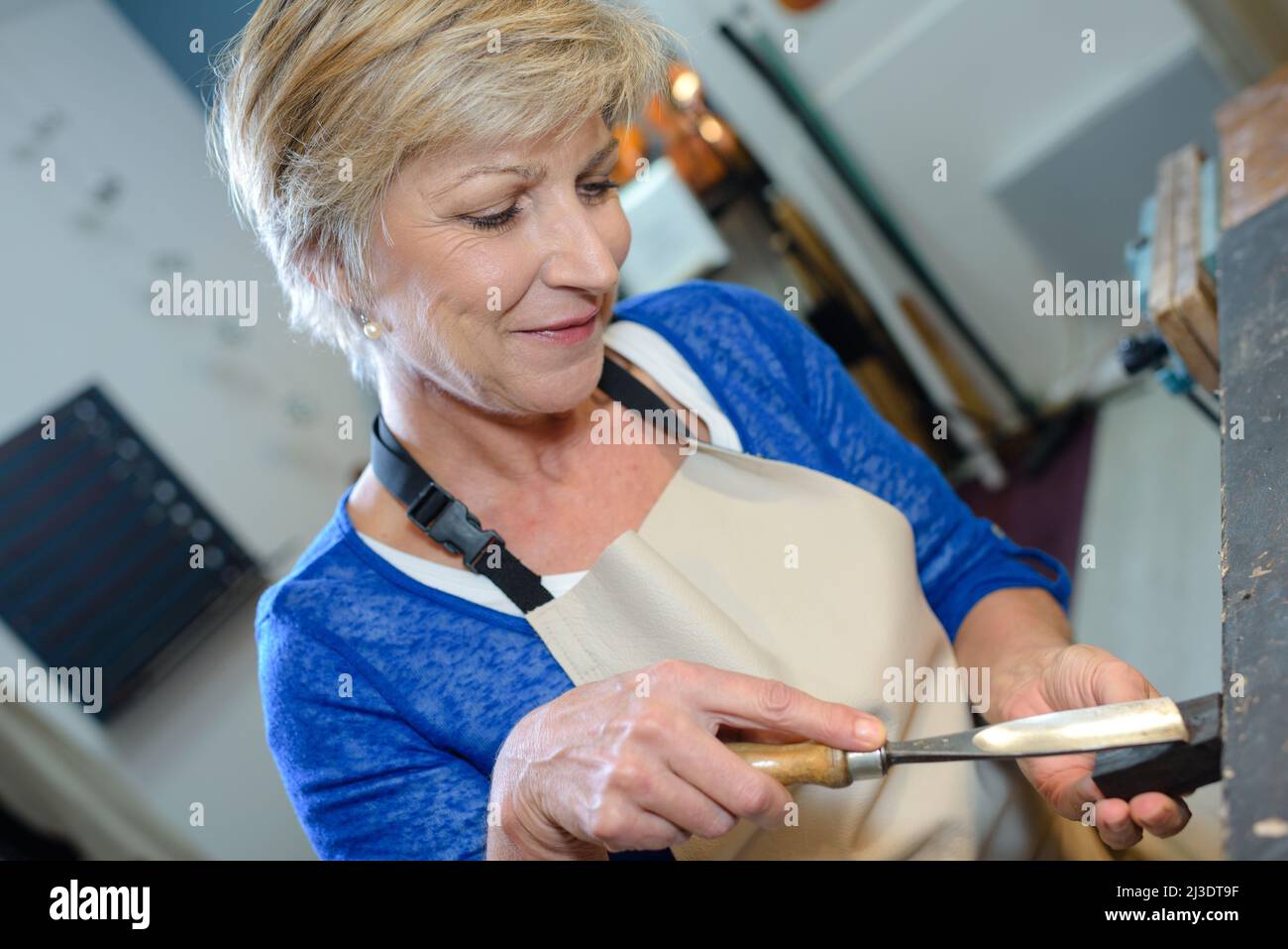 Senior lady using chisel Stock Photo - Alamy