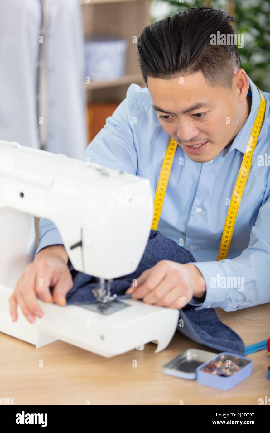 young man tailor working on new clothing Stock Photo - Alamy