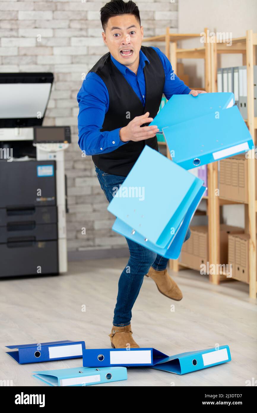 clumsy man drops foldersin an office Stock Photo - Alamy