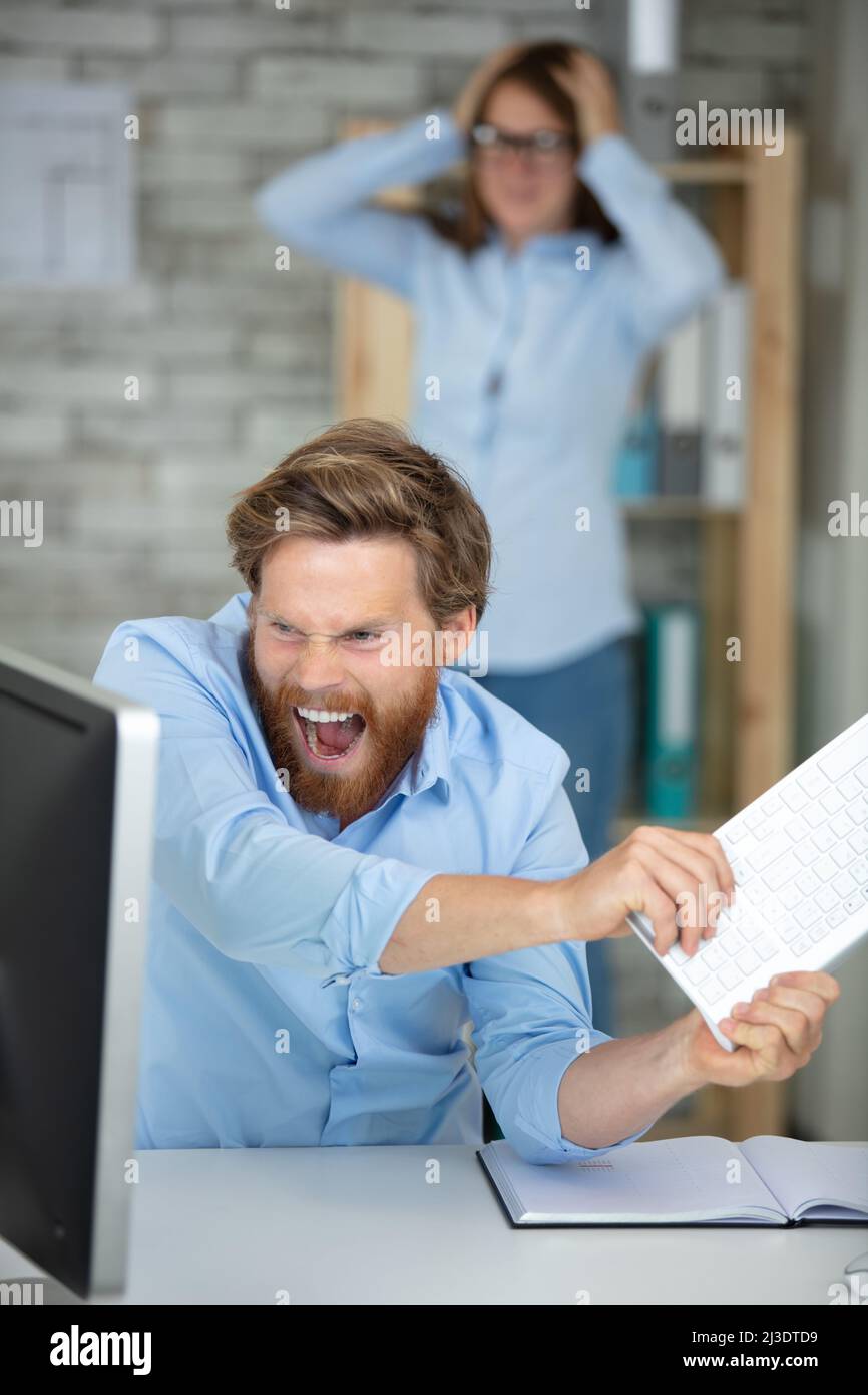stressed businessman breaks the computer with keyboard Stock Photo - Alamy