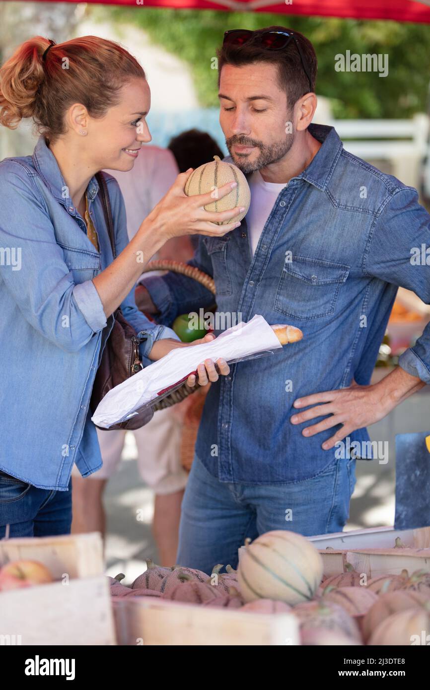 woman giving smell a melon to her man in maket Stock Photo - Alamy