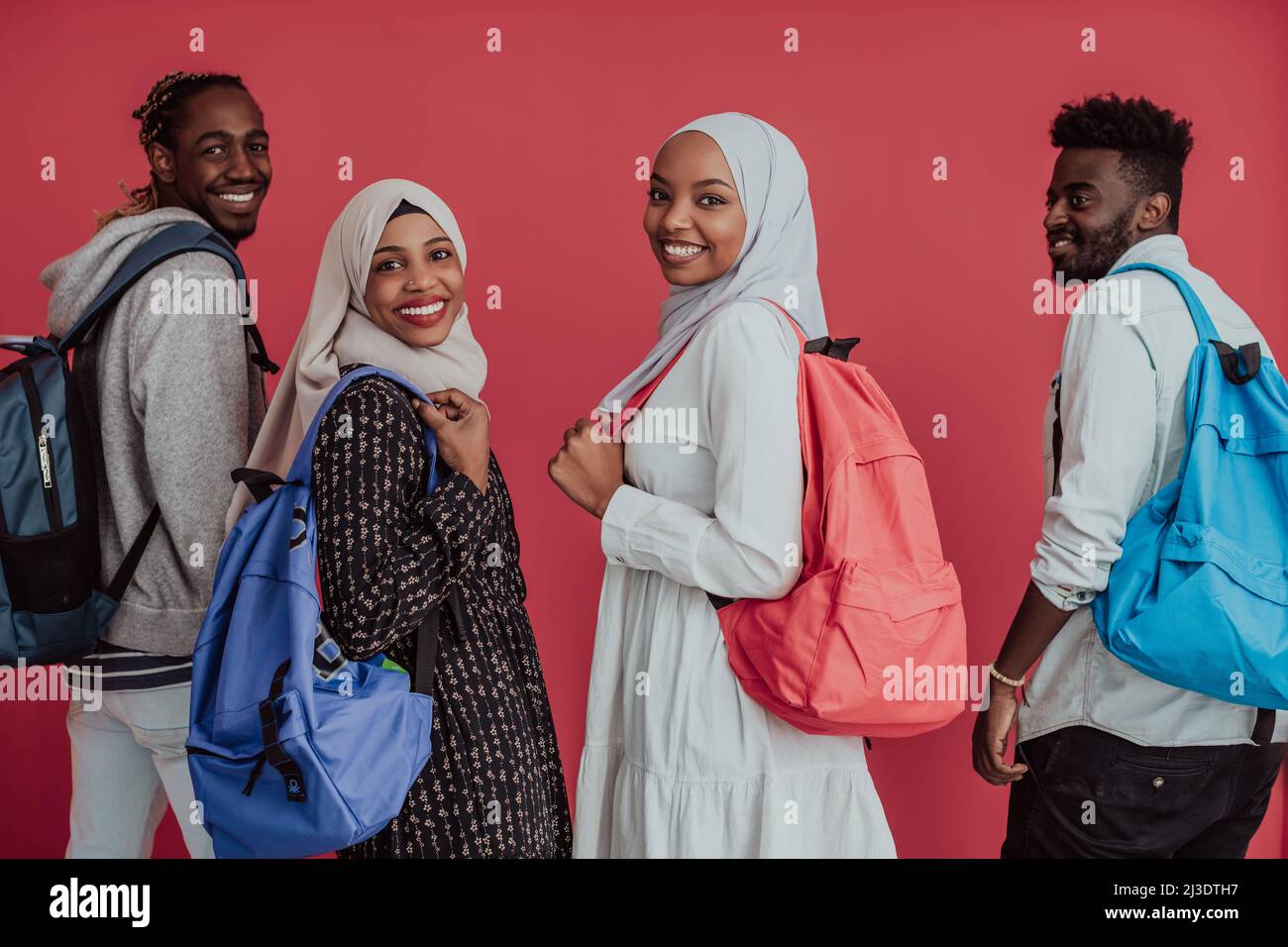 A group of African Muslim students with backpacks posing on a pink ...