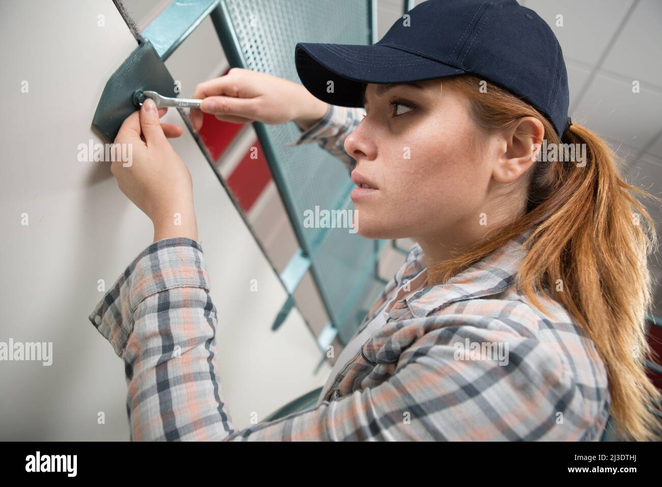 professional female worker using spanner to undo nut Stock Photo - Alamy