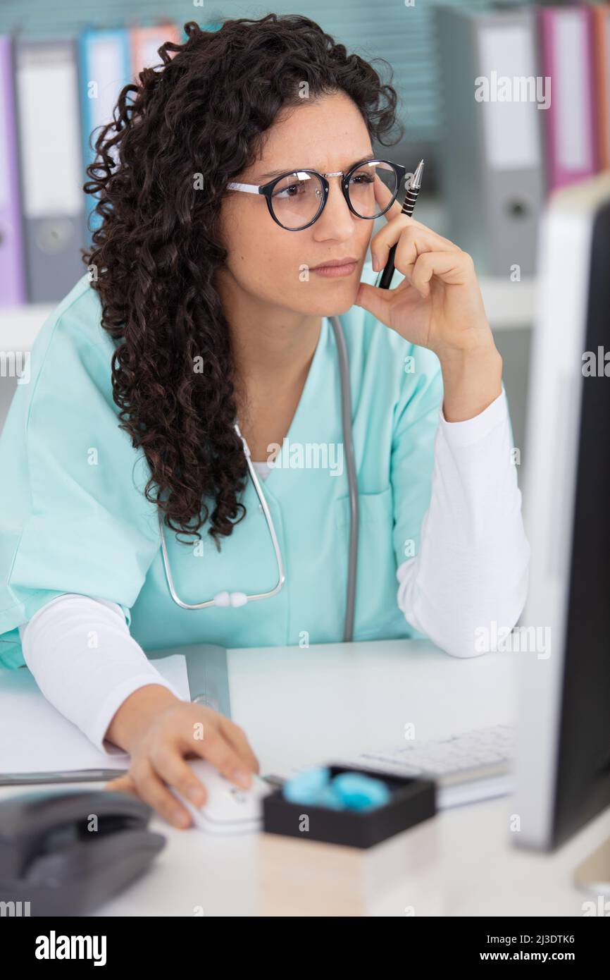pretty young female doctor at desk with telephone Stock Photo - Alamy