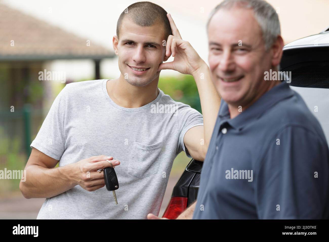 two happy men outside car Stock Photo - Alamy