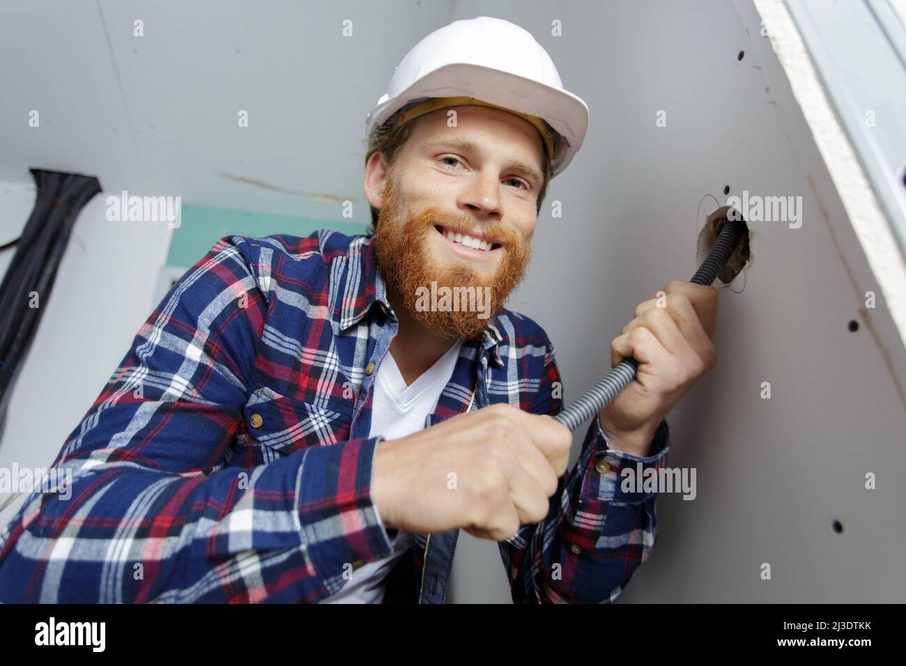 the electrician pull wire from the wall Stock Photo - Alamy