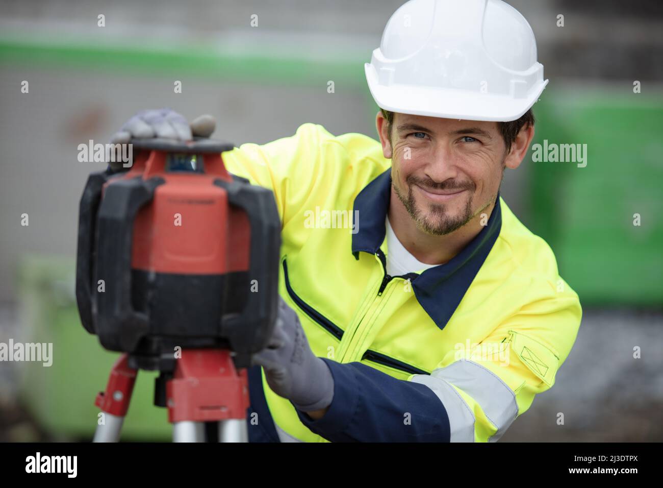 young geometer taking measurements at construction site Stock Photo - Alamy