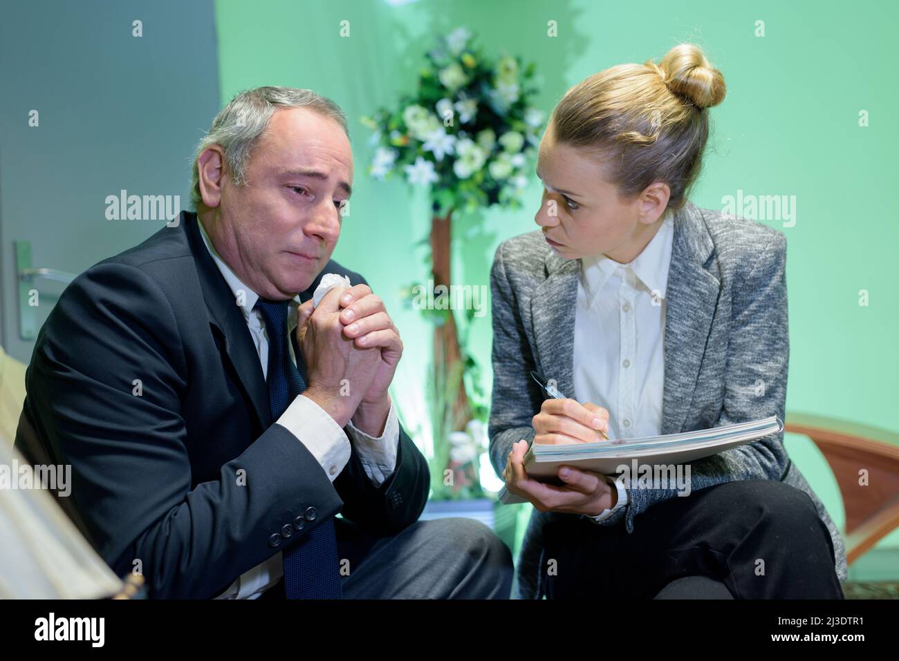 grieving man discussing funeral arrangements with female undertaker ...