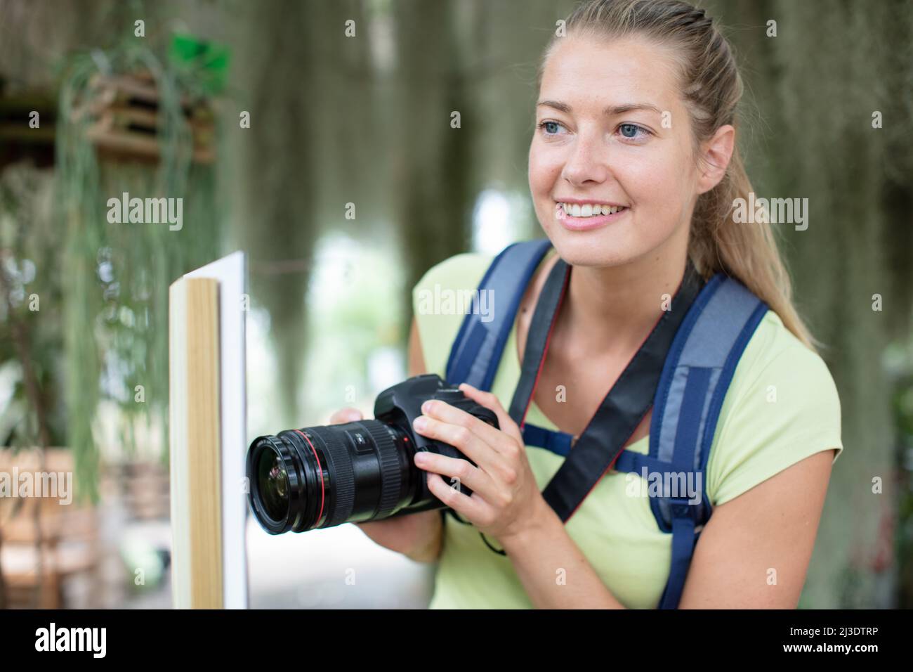 blond female photographer holding camera in nature Stock Photo - Alamy