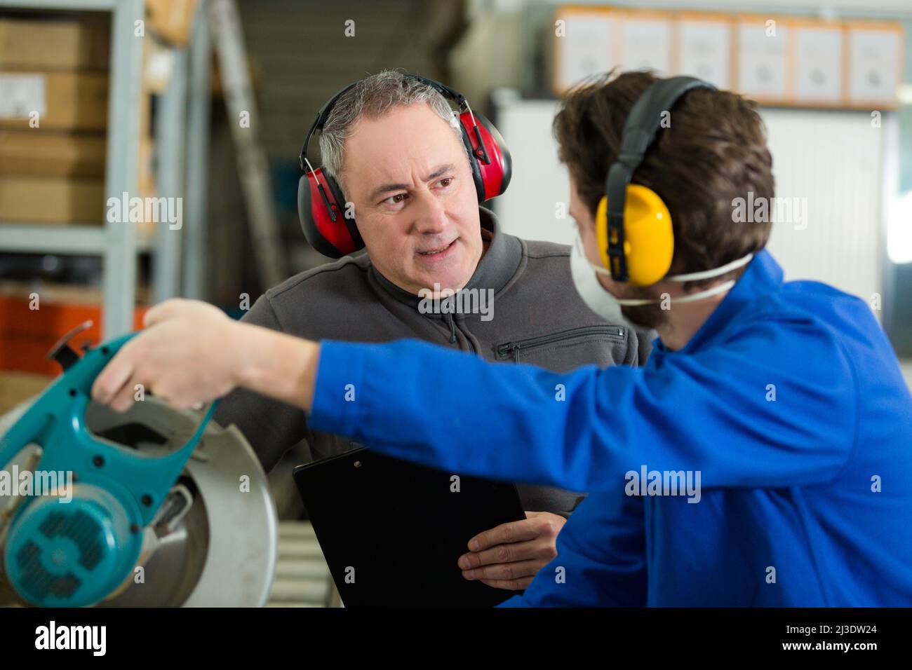 tradesman explaining how to use circular saw to apprentice Stock Photo ...
