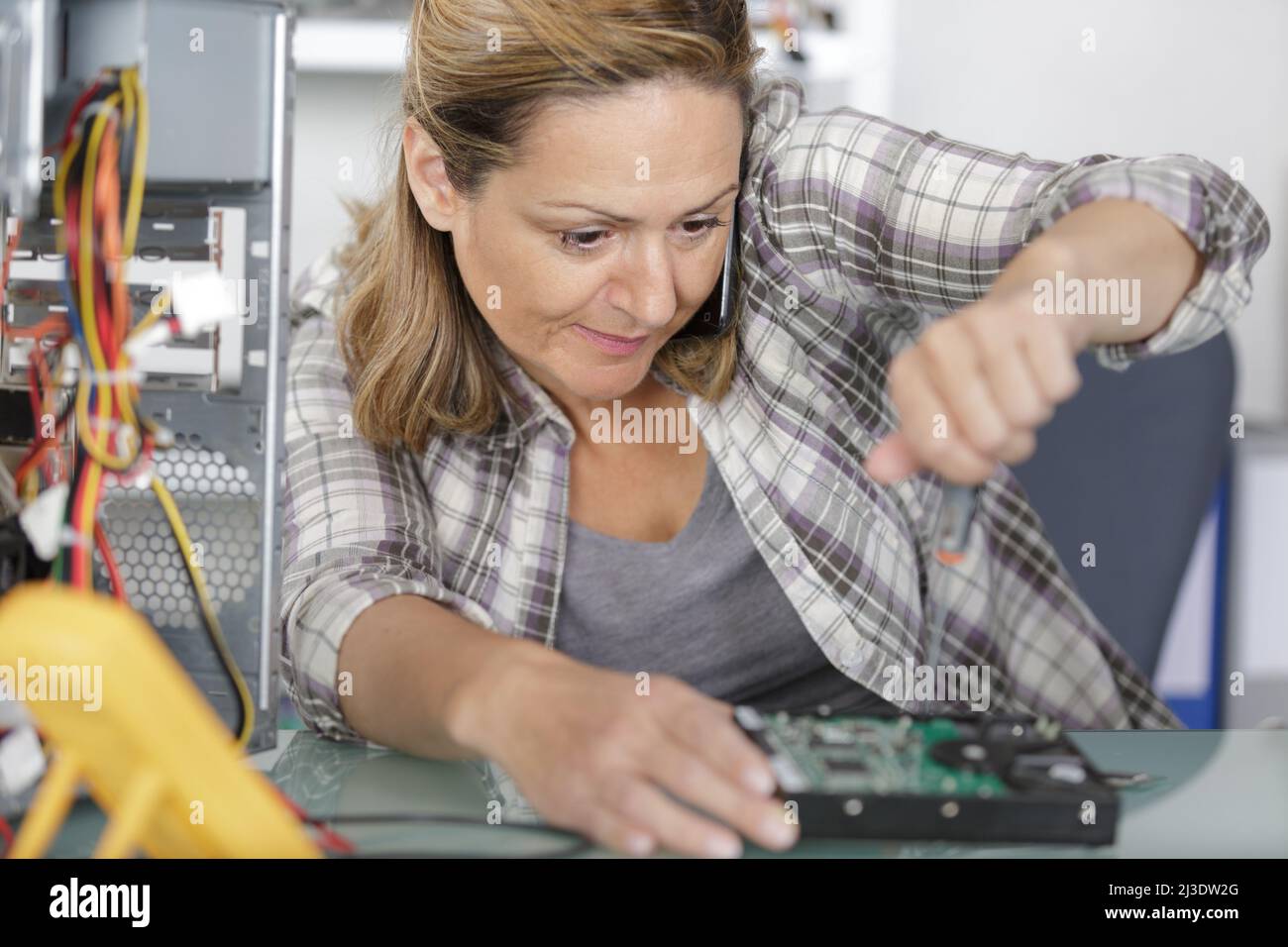 female pc technician on the phone fixing a computer Stock Photo - Alamy
