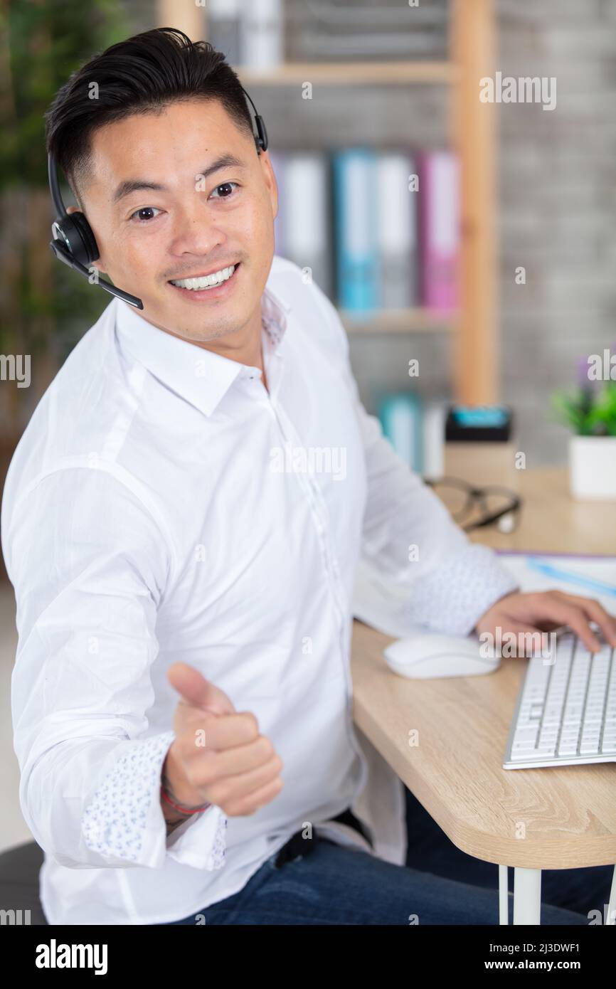 young smiling male call centre operator with a headset Stock Photo - Alamy
