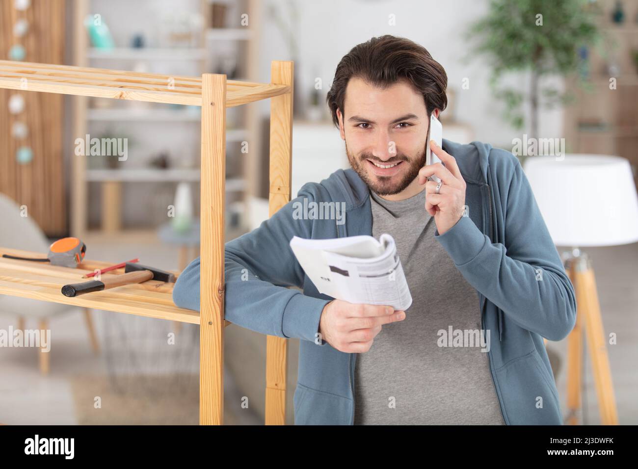 frustrated man putting together self assembly furniture Stock Photo - Alamy