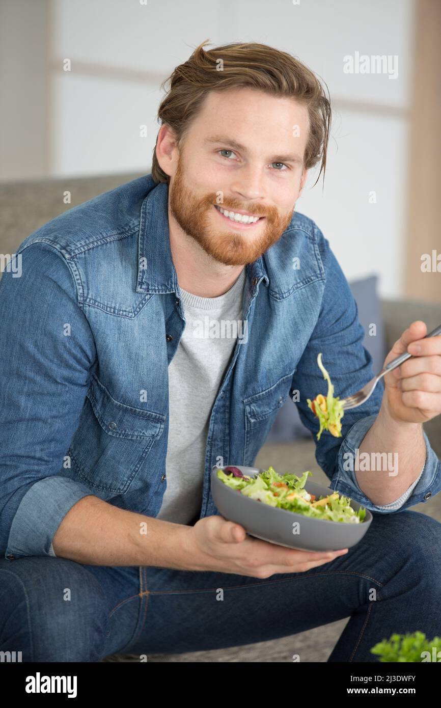Attractive man eating salad sitting hi-res stock photography and images ...