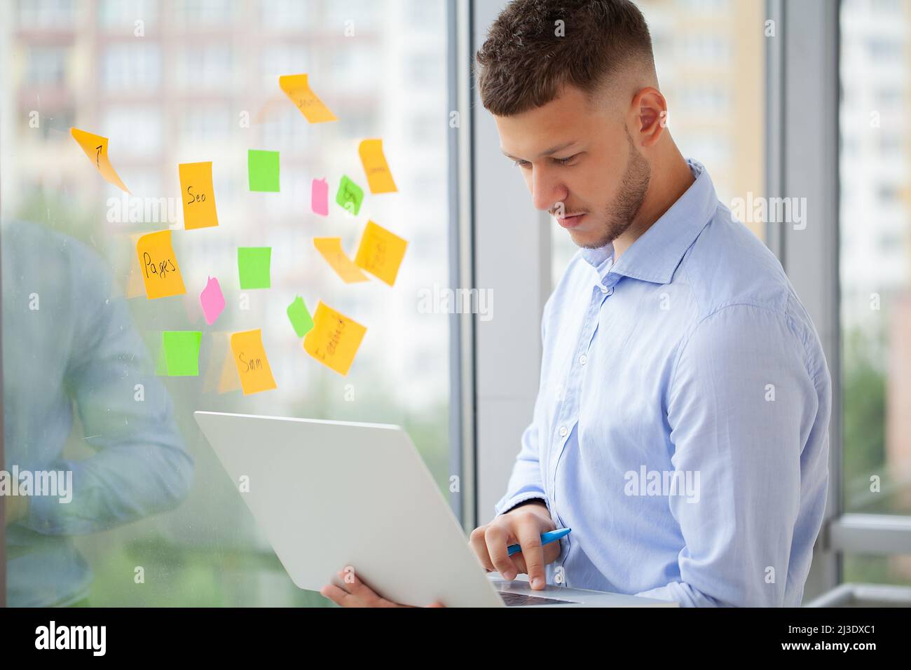 Young handsome businessman using laptop at his office Stock Photo - Alamy