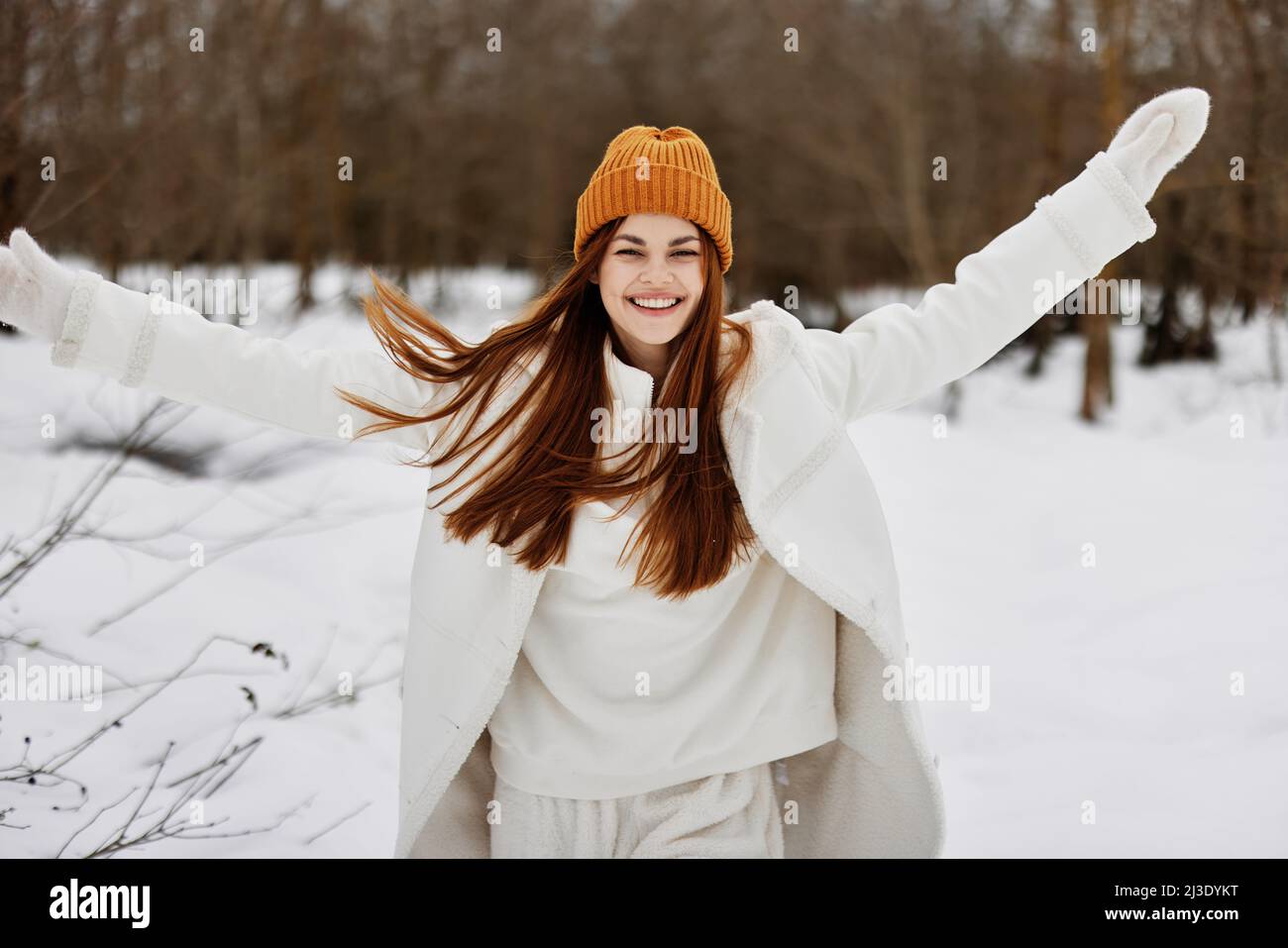 woman in winter clothes in a hat fun winter landscape There is a lot of ...