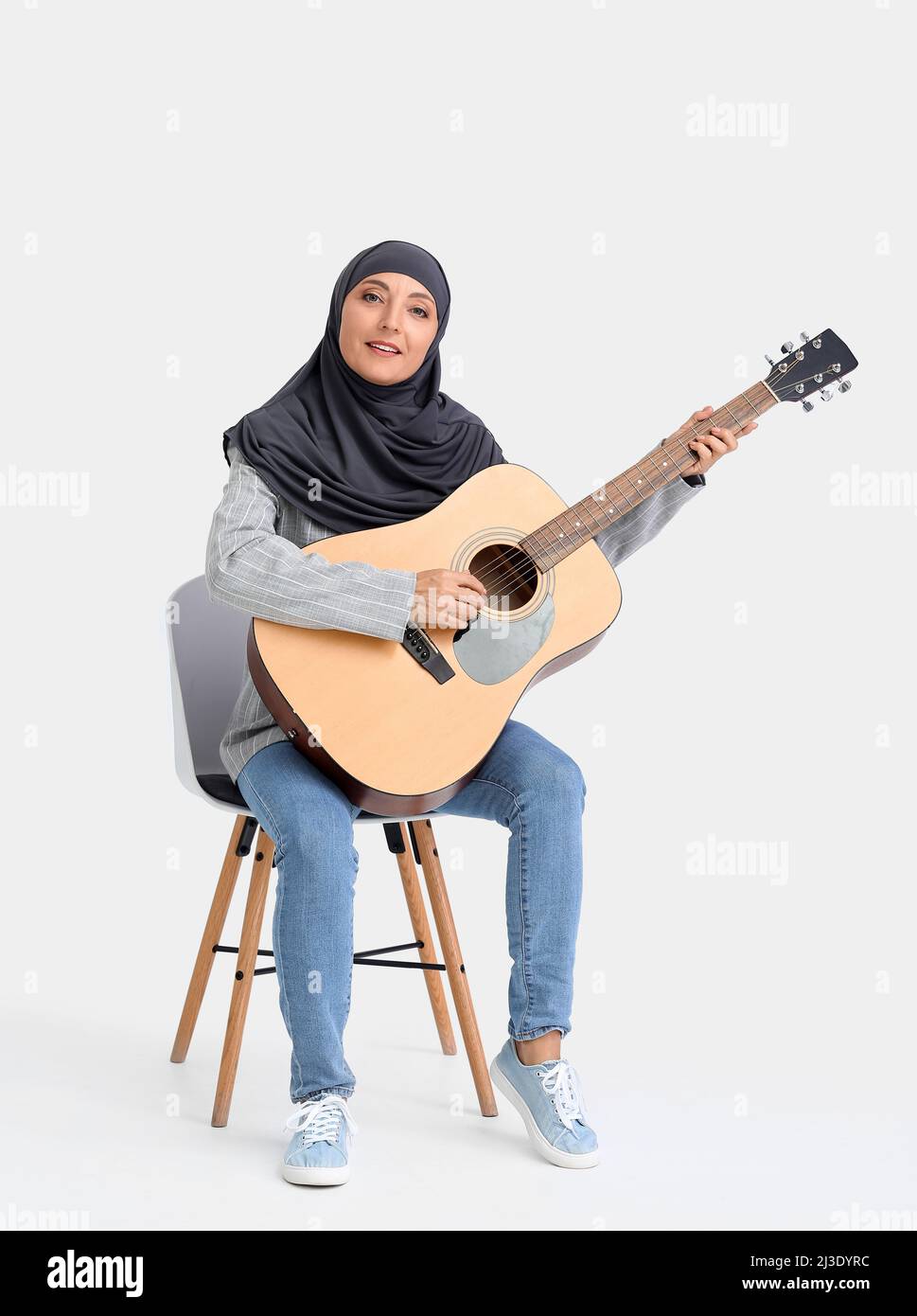 Muslim music teacher with guitar on light background Stock Photo - Alamy