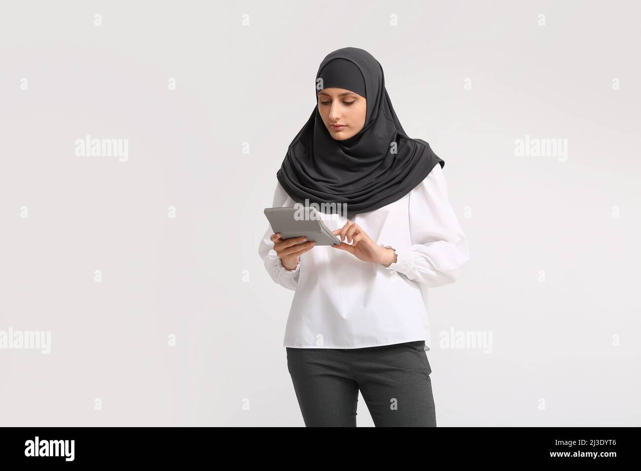 Muslim secretary with calculator on light background Stock Photo - Alamy