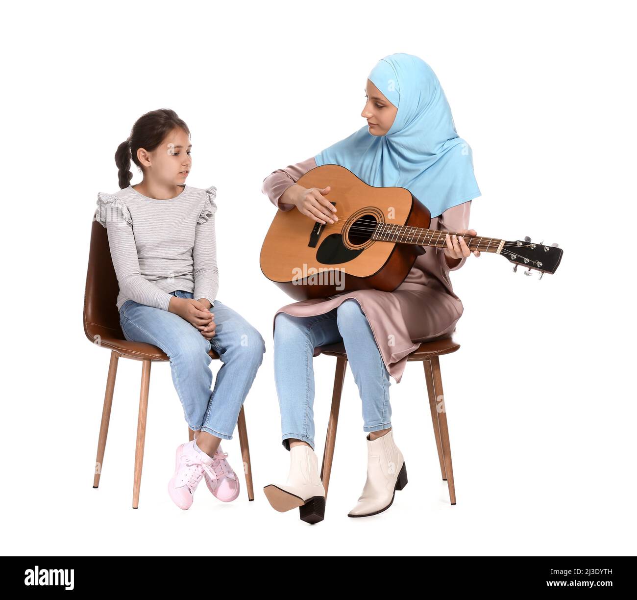 Private Muslim music teacher giving guitar lesson to little girl on ...