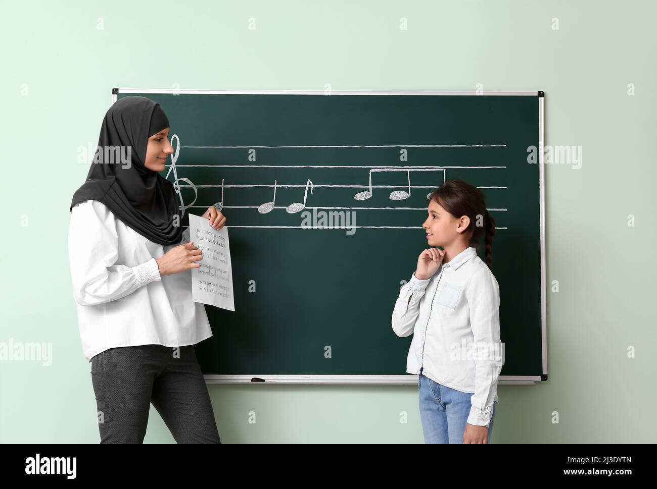Muslim music teacher giving lesson at school Stock Photo - Alamy