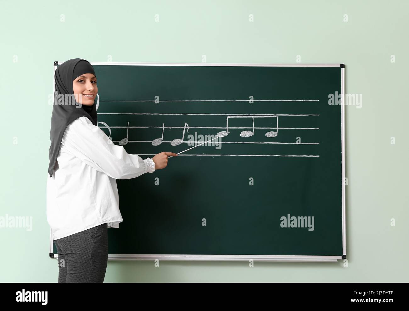 Muslim music teacher giving lesson at school Stock Photo - Alamy