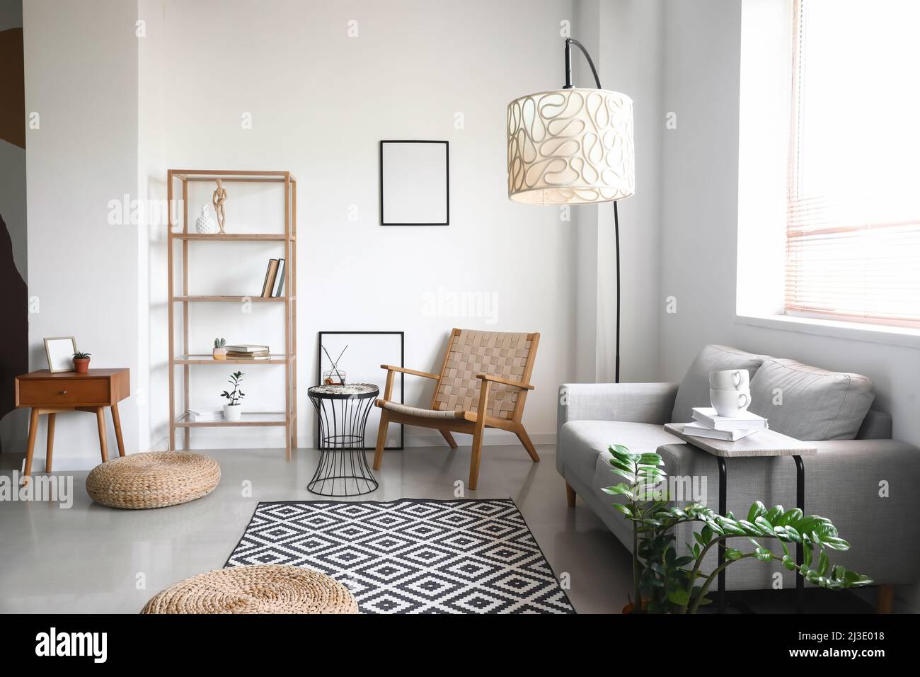 Interior of light living room with sofa, wooden armchair and standing ...