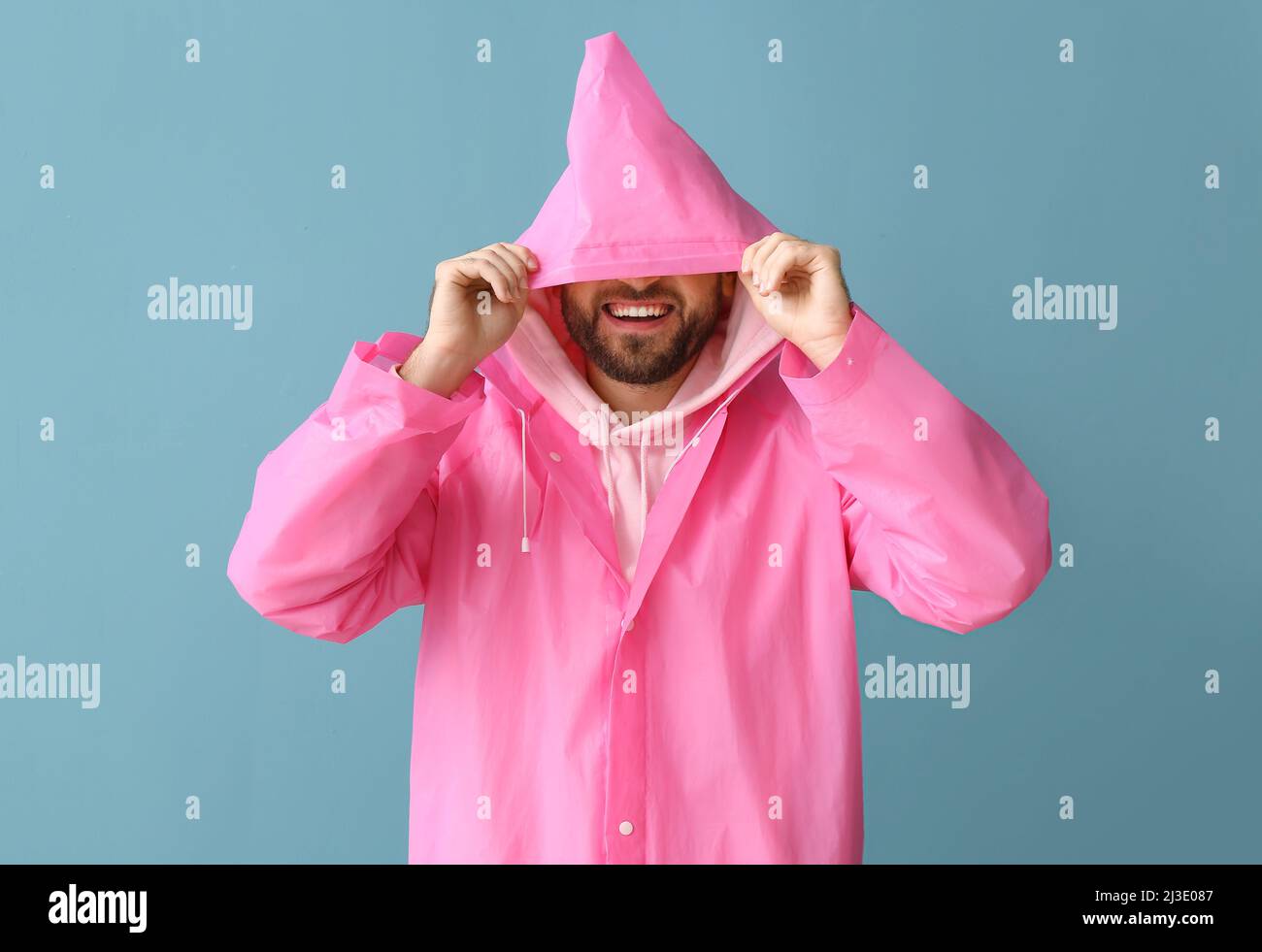 Young man in stylish raincoat on color background Stock Photo - Alamy