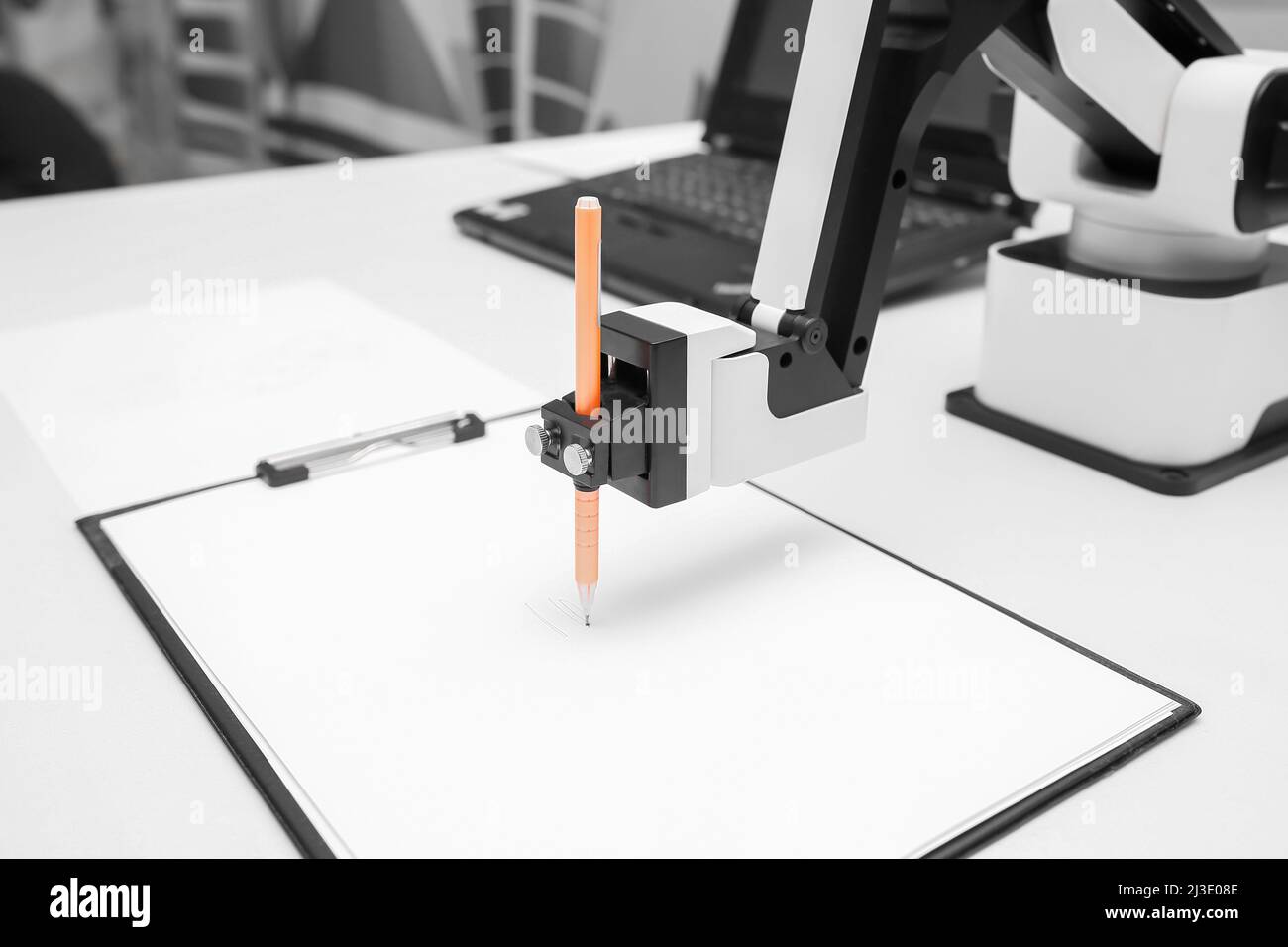 Futuristic robotic arm with pen and blank paper sheet at exhibition ...