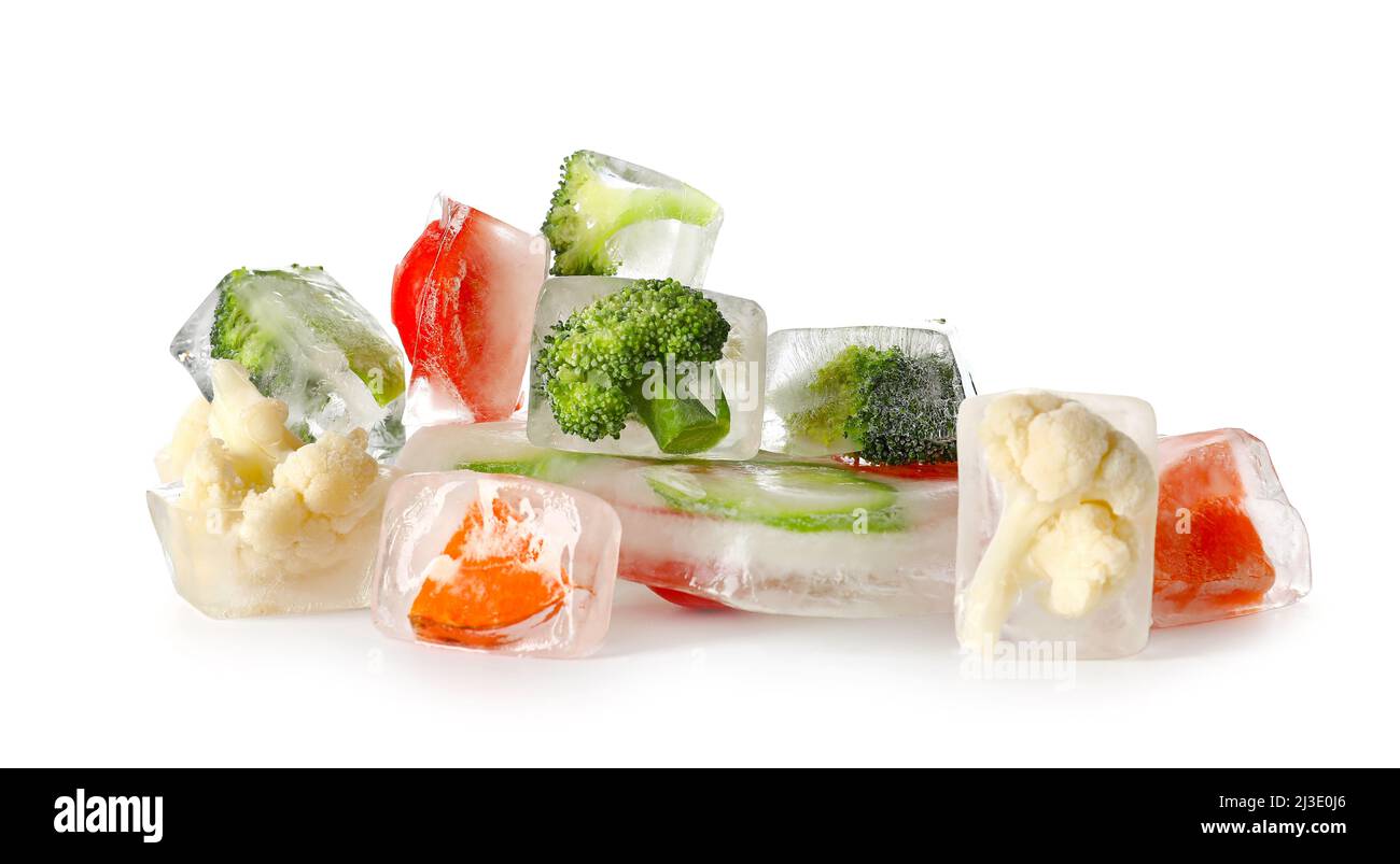 Fresh vegetables frozen in ice on white background Stock Photo - Alamy