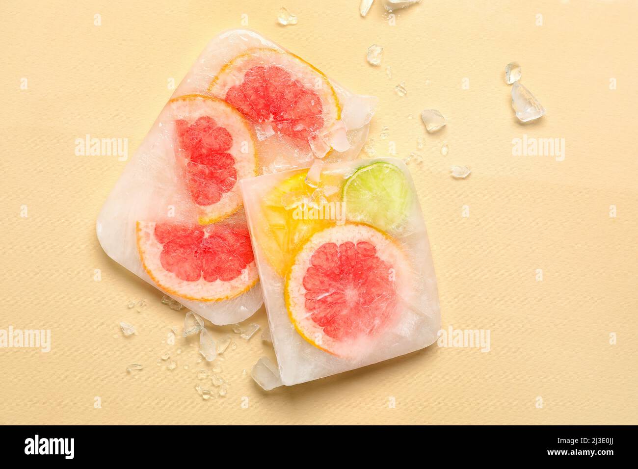 Fresh fruits frozen in ice on beige background Stock Photo - Alamy