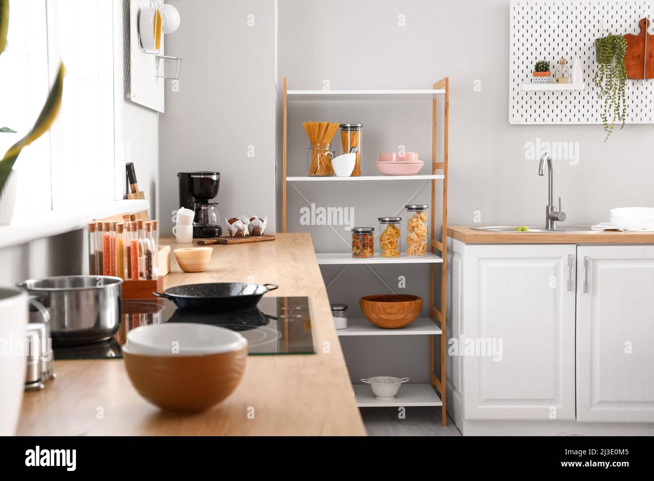 Stylish counter with dishware and modern shelving unit in kitchen Stock ...