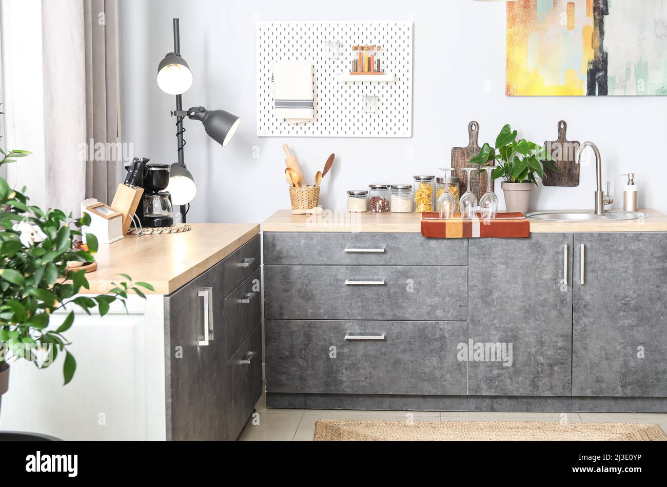 Wooden counters with silver sink and cookware in light kitchen Stock ...