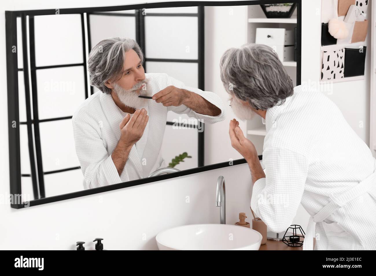 Mature man taking care of his beard and mustache in bathroom Stock ...
