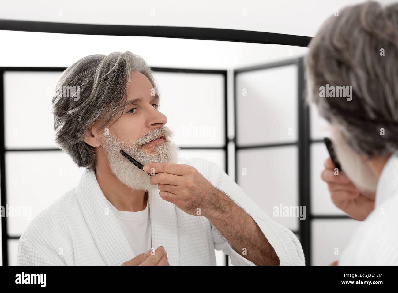 Mature man taking care of his beard and mustache in bathroom Stock ...