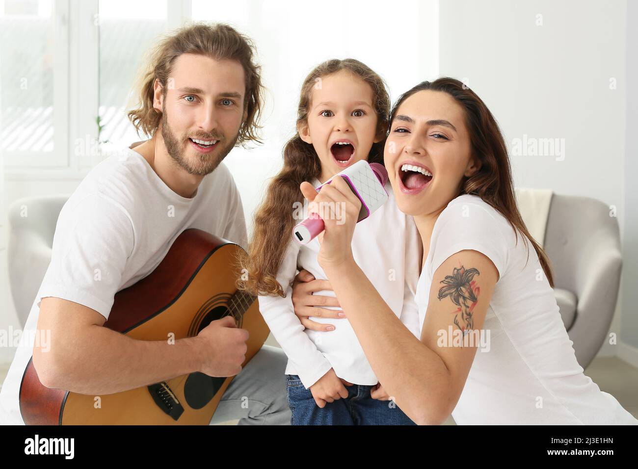 Happy family singing song at home Stock Photo - Alamy