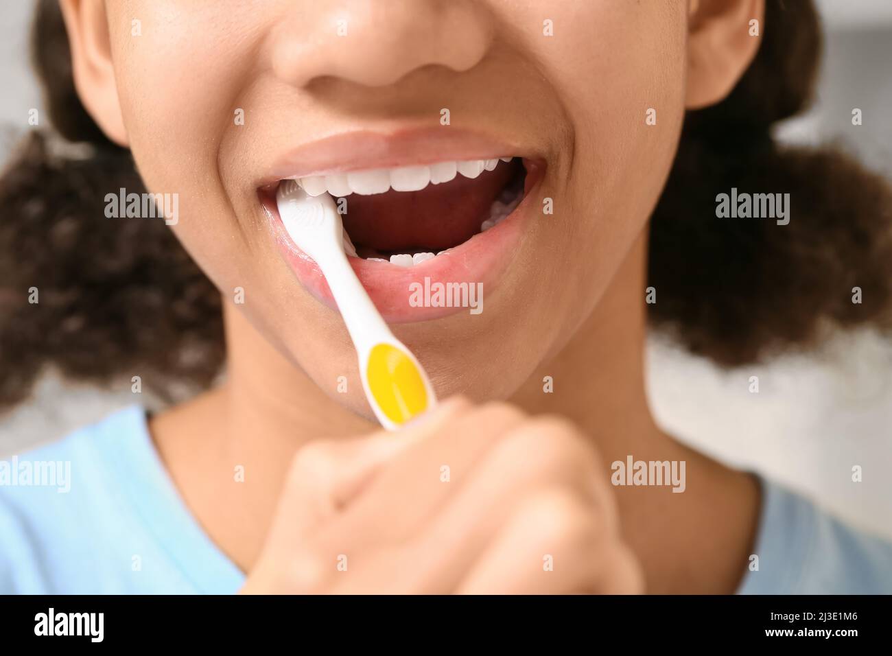 African-American teenage girl brushing teeth in bathroom, closeup Stock ...