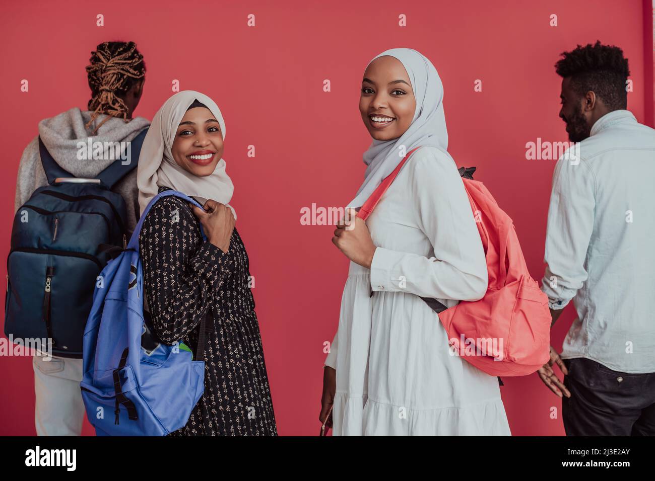 A group of African Muslim students with backpacks posing on a pink ...