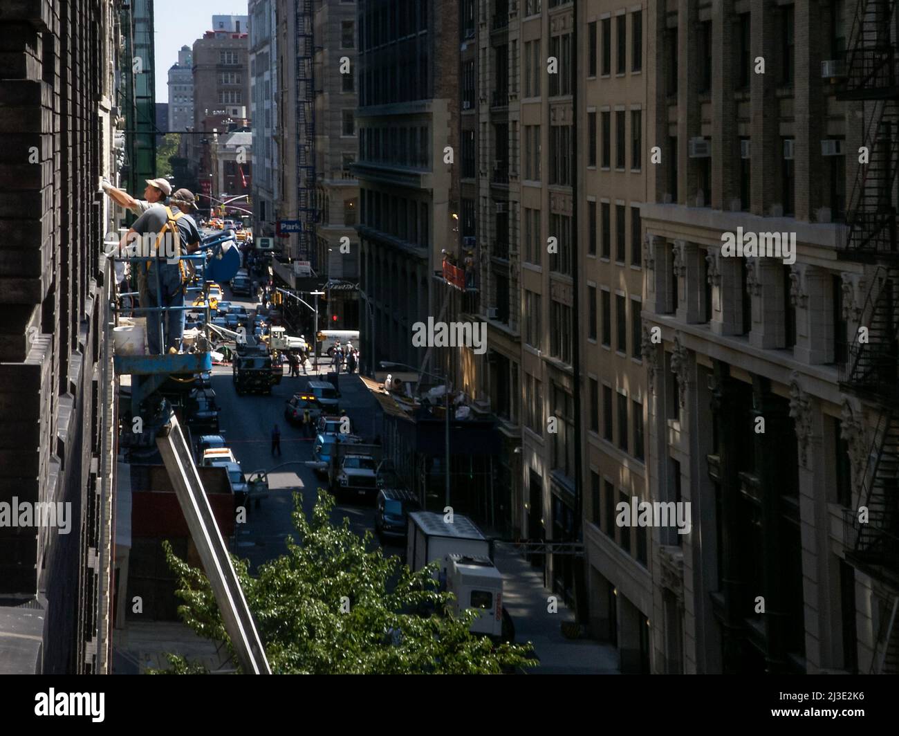 workers repairing a 6th floor window standing on a platform at West ...