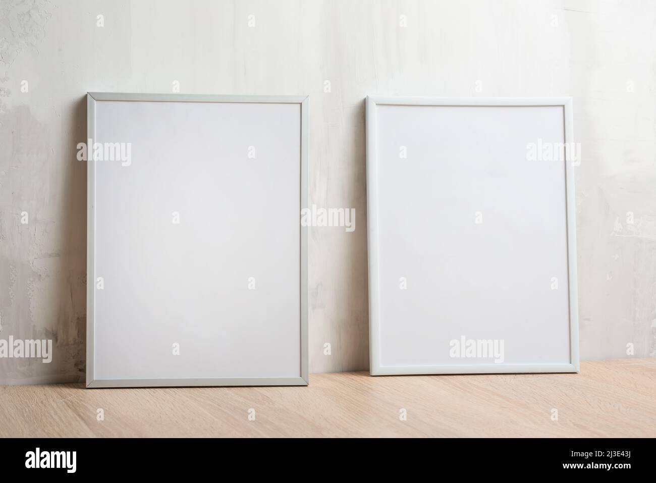 Two white frames on the wall background. The concept of design and font ...