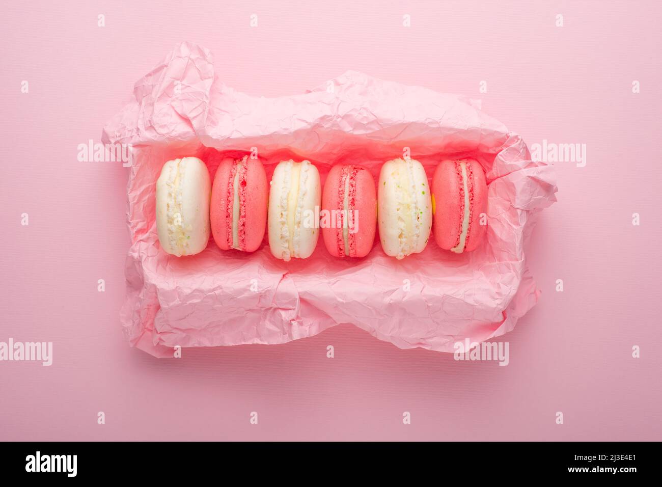 Macaroons in a box on a light pink background, flatlays Stock Photo - Alamy