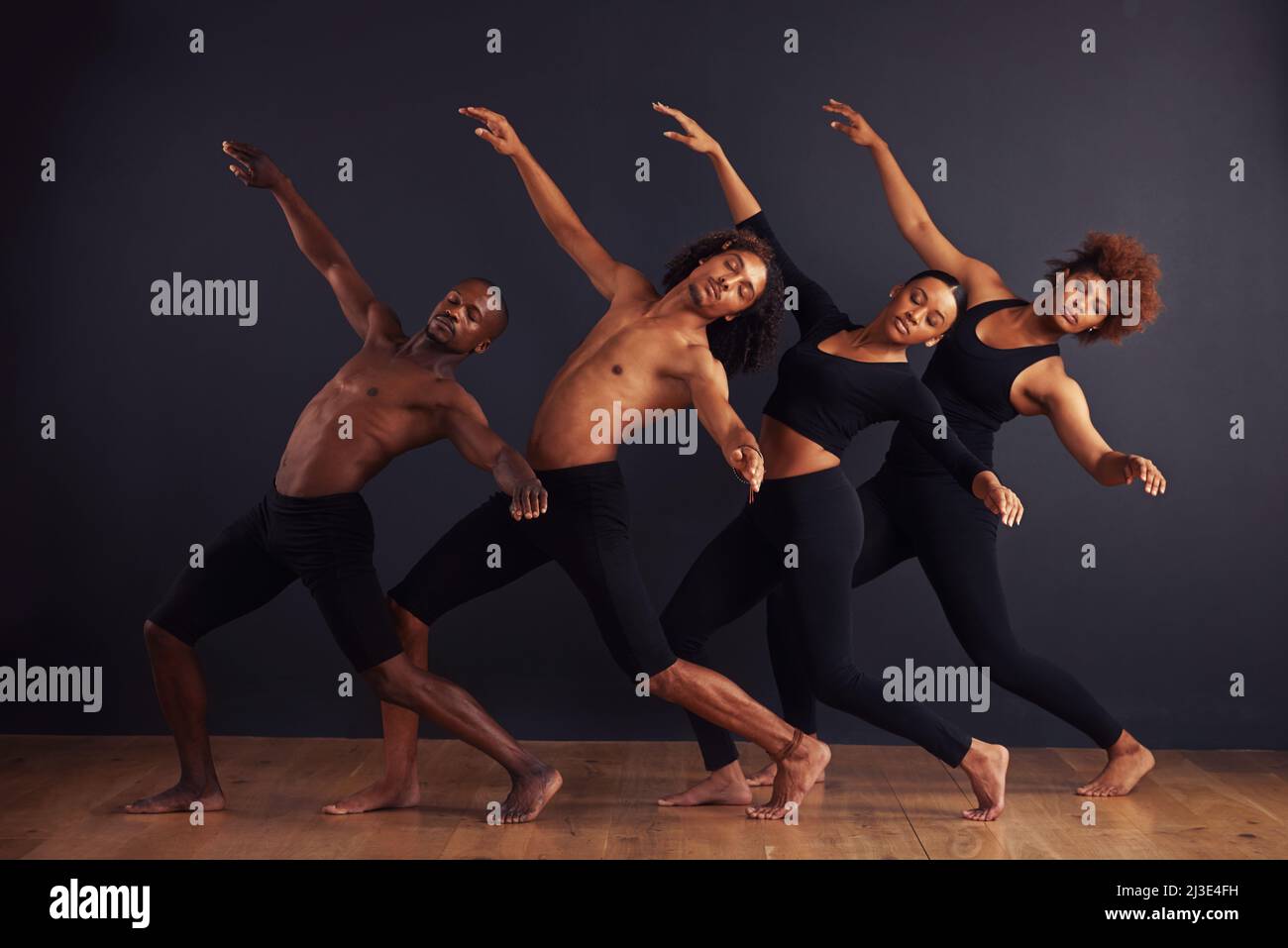 Perfectly synchronised. A group of dancers performing a dramatic pose ...