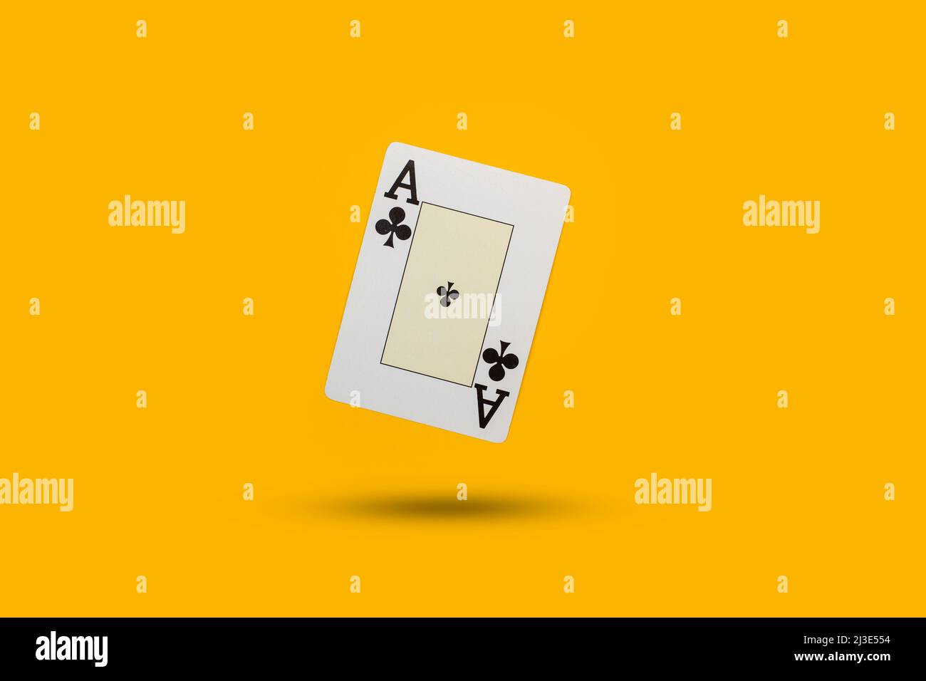 An ace of clver card floating on a yellow background with copy space ...