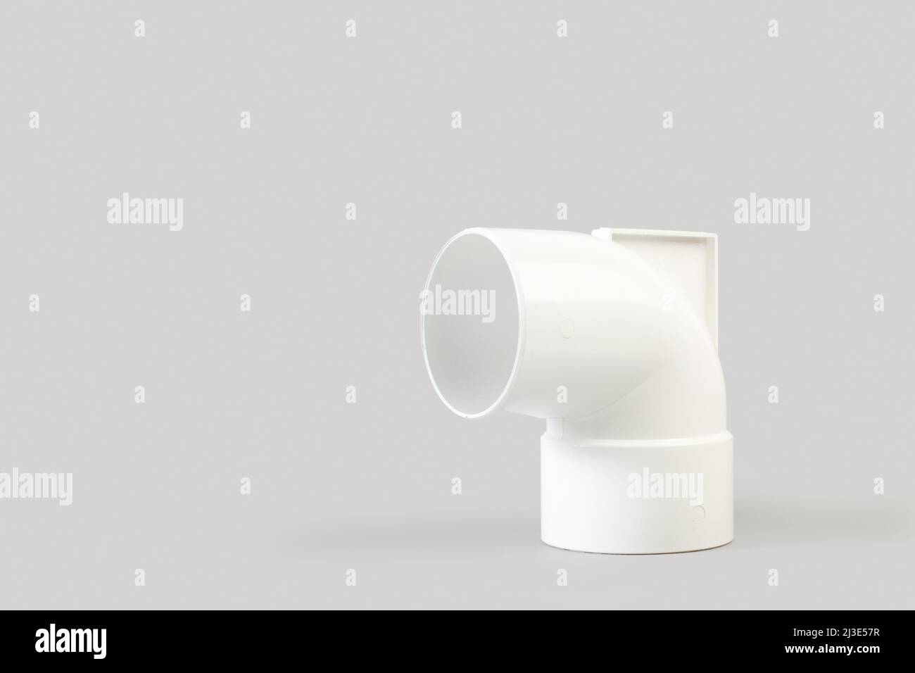 White plastic connection pipe on a gray background with copy space ...