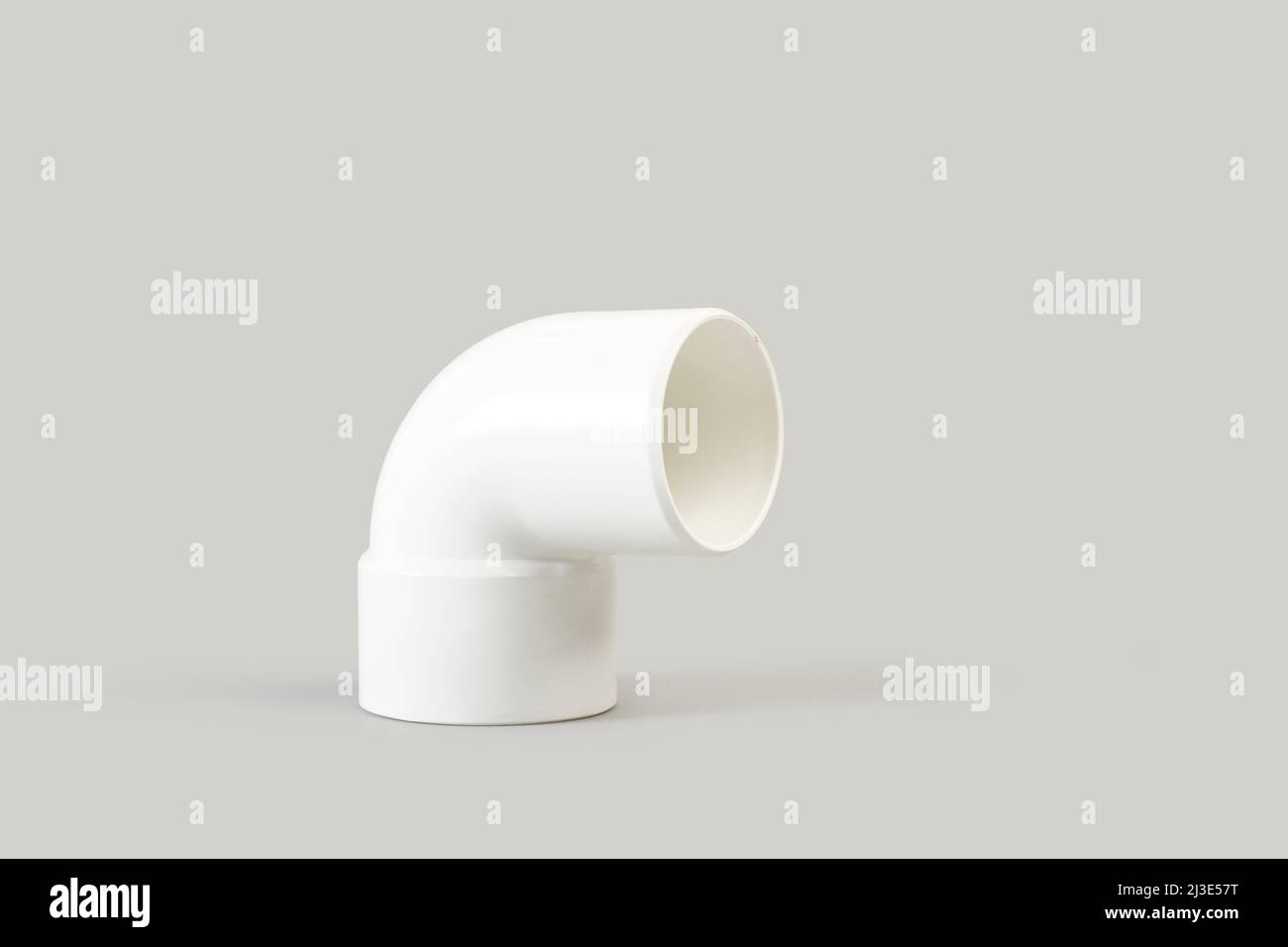 White plastic connection pipe on a gray background with copy space ...