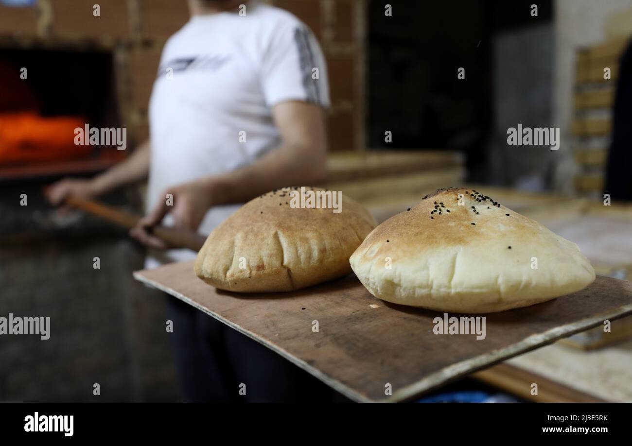 Nablus. 7th Apr, 2022. A Palestinian baker uses a traditional wood ...