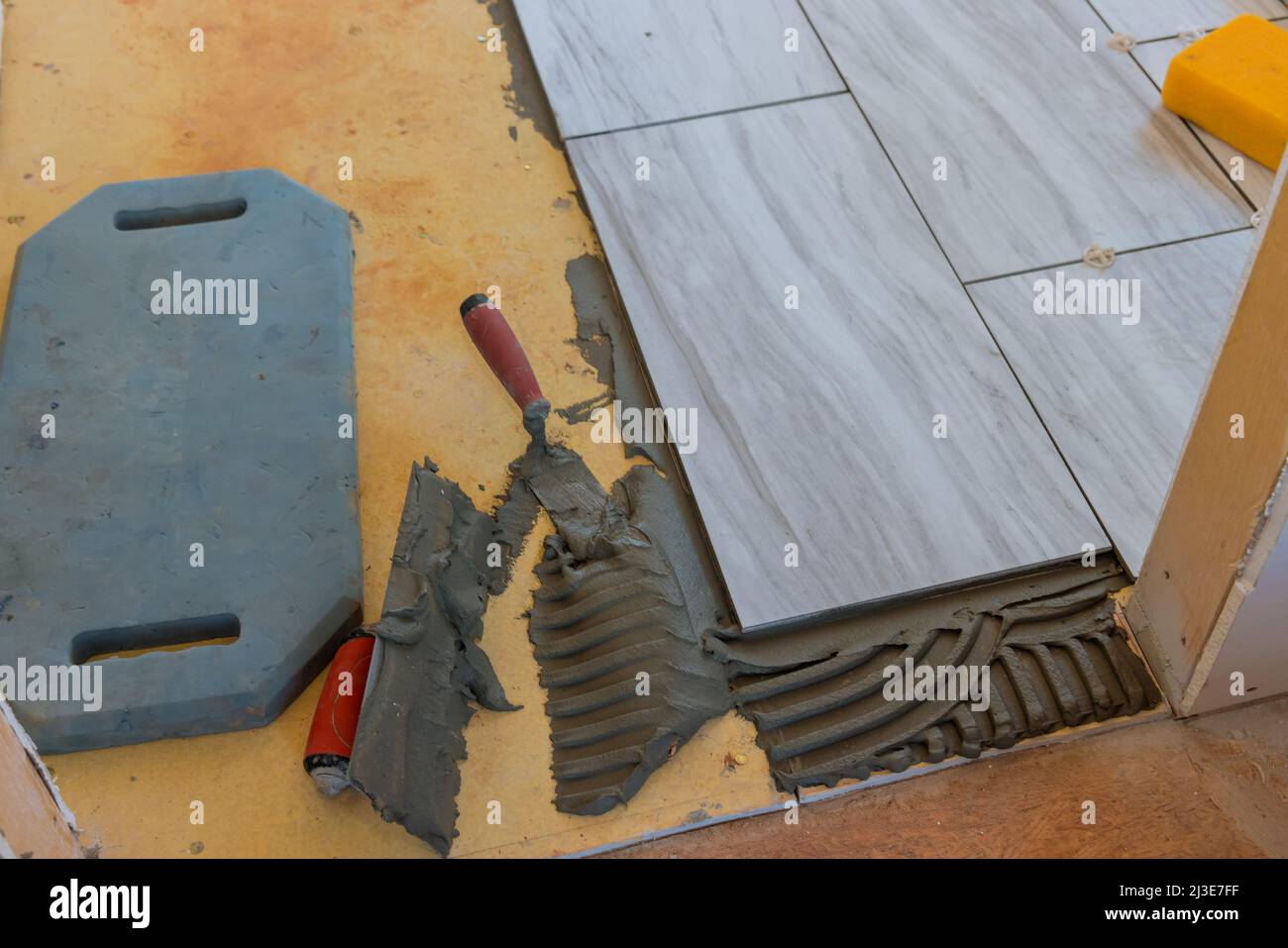 Tiler builder worker installing floor tile at repair renovation Stock ...