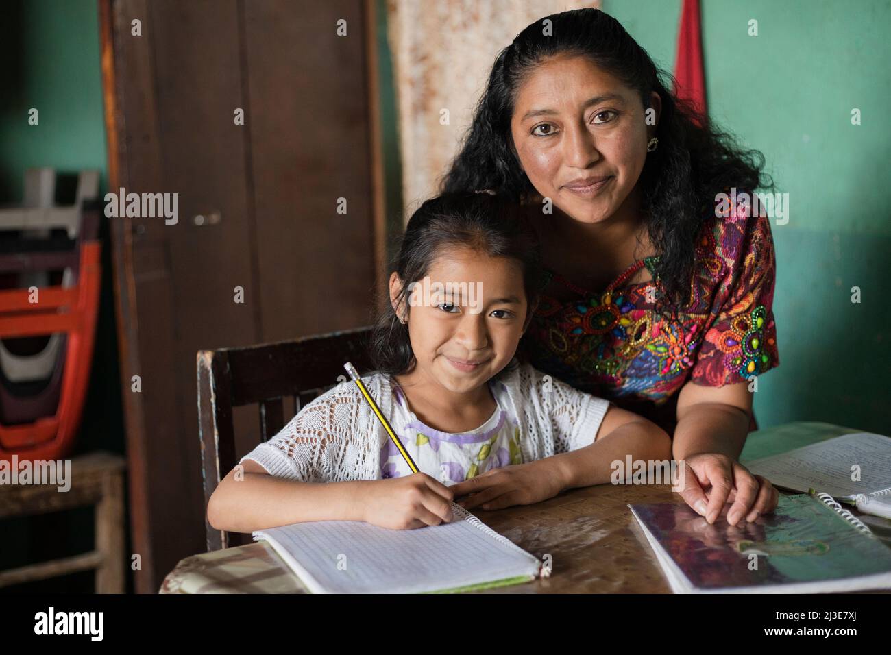 Hispanic mom helping her little daughter do her homework - Mom teaching ...